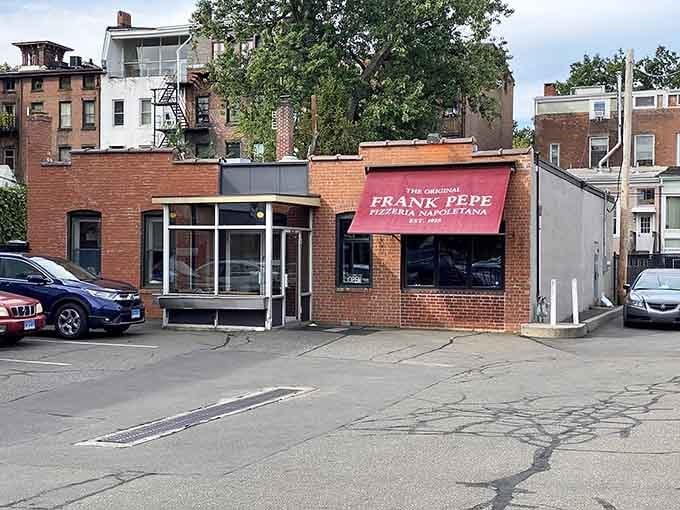The original Frank Pepe sign glows like a beacon for every hungry soul on Wooster Street.