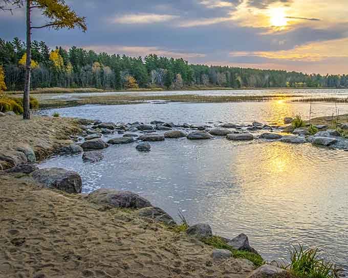 Golden sunset melts across the sandy shore, turning this quiet headwaters scene into something straight off a calendar cover.