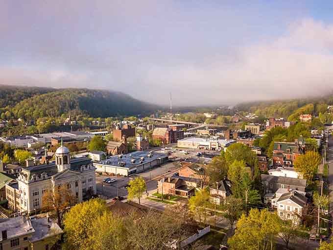 Morning mist rolls over Little Falls like nature's own welcome mat, framing rooftops and steeples in pure magic.