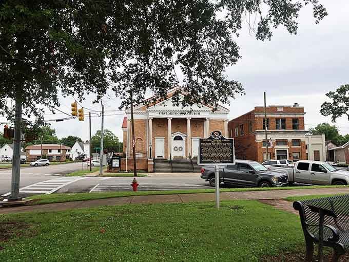 A historic church and a weathered landmark sign share a corner, reminding you that Tuscumbia takes its roots seriously.