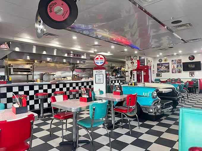 A turquoise classic car parked inside a diner. Somehow, this is exactly where it belongs.
