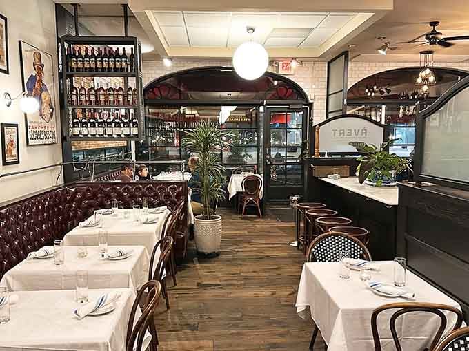 Tufted leather banquettes and crisp white linens create the kind of warmth that makes strangers feel like regulars.