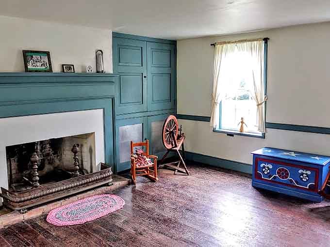 That bold teal woodwork and spinning wheel tell you everything about early nineteenth-century Ohio domestic life.