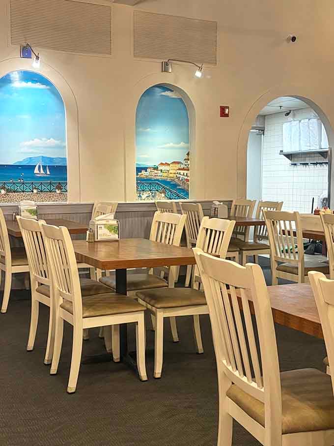 Painted harbors and white chairs make this dining room feel like a Mediterranean vacation without the jet lag.