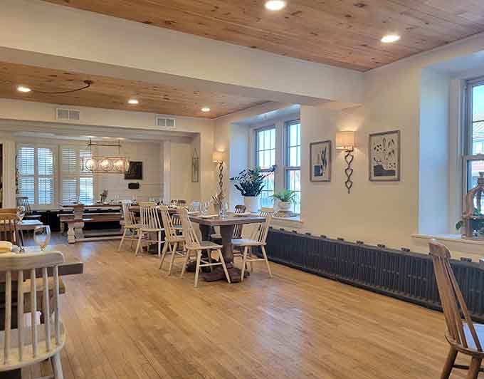Light wood ceilings, white chairs, and natural light pouring in. This dining room means serious, comfortable business.