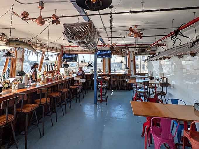 Boats on the ceiling, mismatched chairs, copper fans overhead. This interior says "we had fun building this, and you will too."