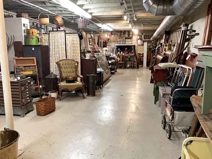 Stroll down this wide, well-lit basement aisle to discover vintage armchairs, woven baskets, old baby strollers, and rustic furniture.