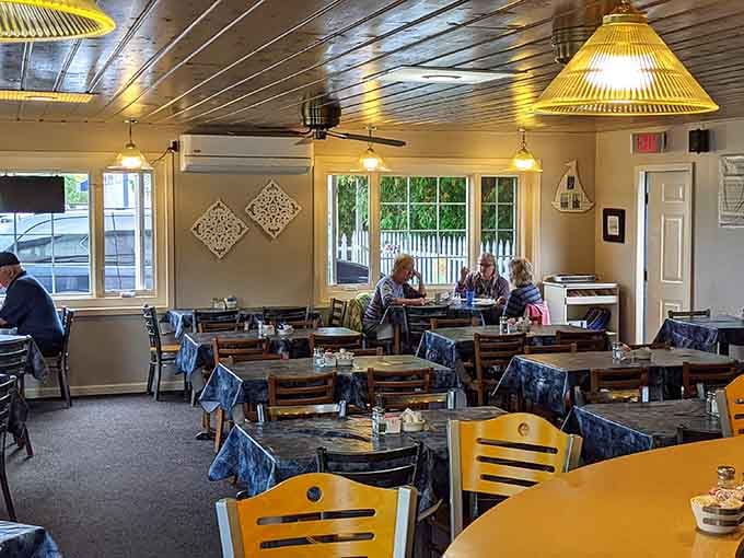Yellow lampshades cast a warm glow over wooden tables where locals and visitors become temporary breakfast companions.