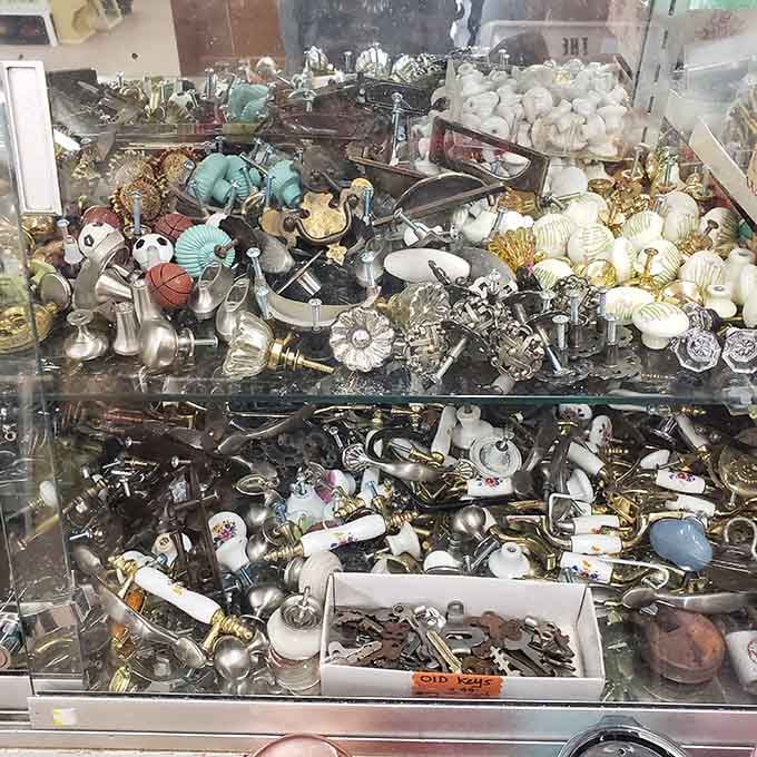 A glass case full of door knobs and old keys, because someone out there needs exactly this.