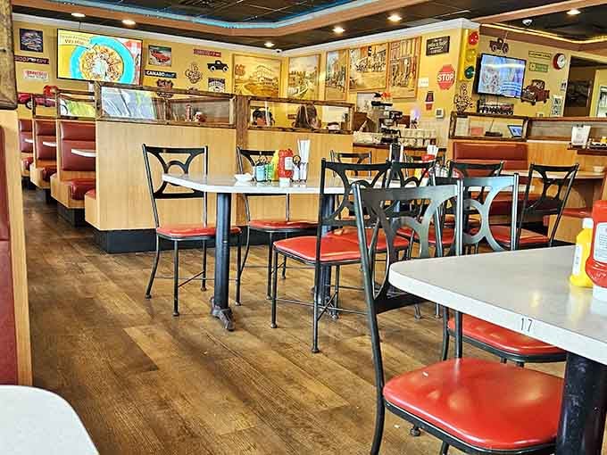 Classic diner seating with cheerful yellow walls creates the kind of welcoming atmosphere that makes strangers feel like regulars.