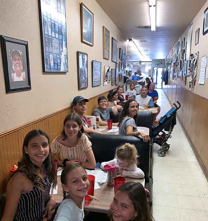 Three generations squeezed into one booth, red cups everywhere, and smiles that say the food hasn't let anyone down yet.
