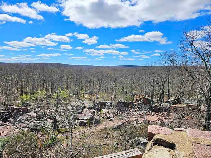Take in this spectacular view of sprawling woodlands and giant pink granite boulders under a beautiful, cloud-dotted blue sky.