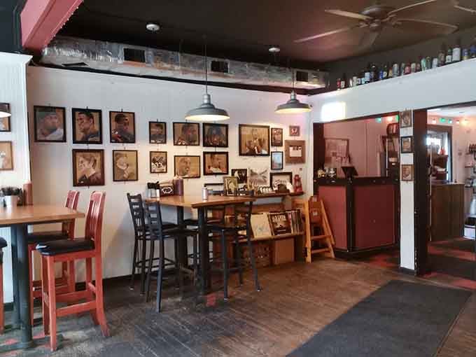 Framed portraits covering every wall, warm pendant lights overhead, and mismatched chairs that somehow feel exactly right together.