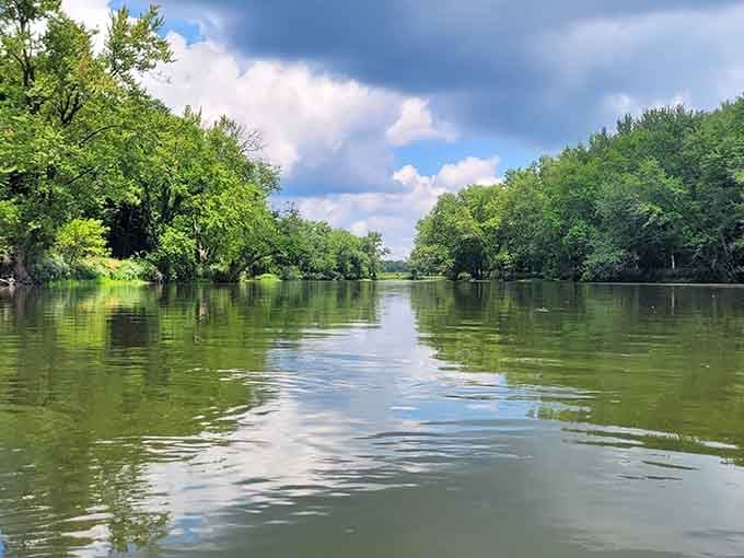 A corridor of green trees lines both banks, turning a simple float into something that feels genuinely cinematic.