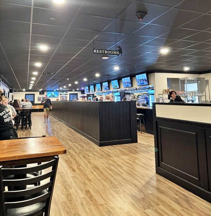 Light wood floors, dark paneling, and TV screens everywhere. This is exactly where you want to spend a Friday night.