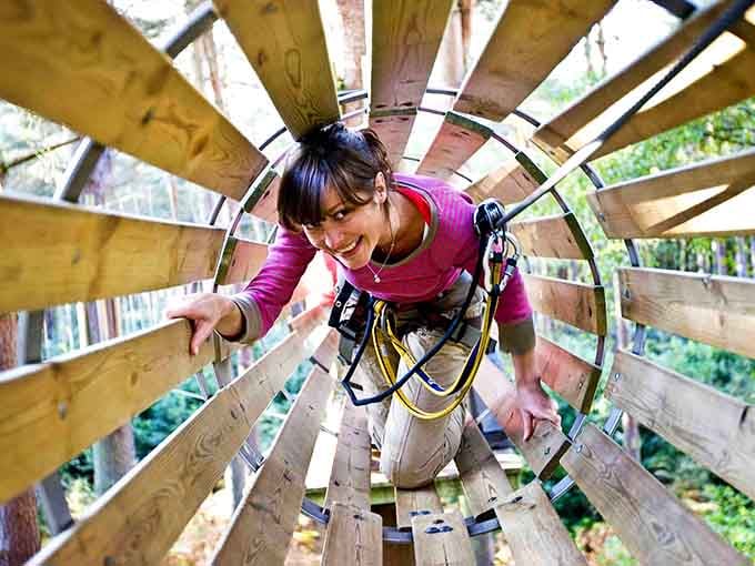 That grin says it all, crawling through a wooden barrel tunnel mid-canopy is genuinely life-changing.
