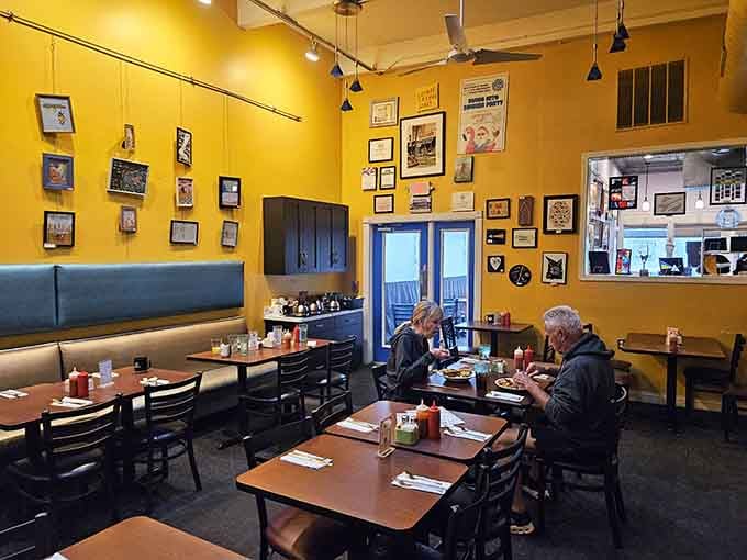 Warm yellow walls, framed artwork everywhere, and zero pretension. This is what a real neighborhood cafe looks like.