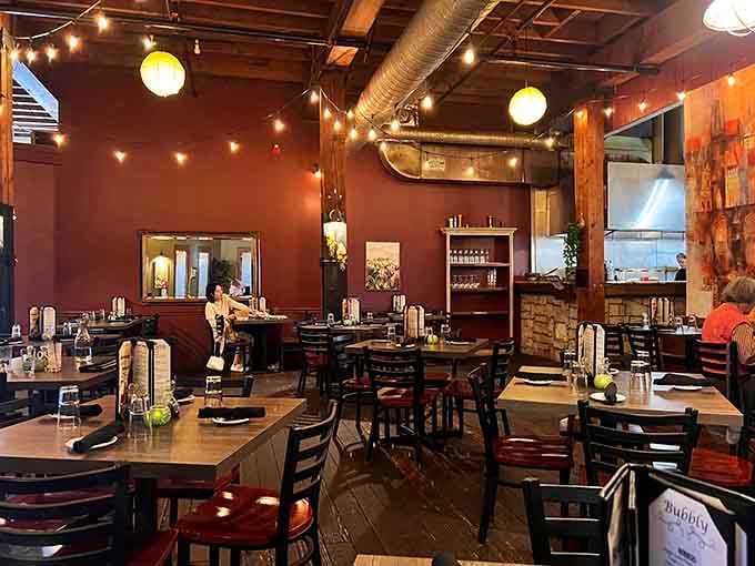 Warm red walls, string lights, and exposed beams. This dining room doesn't just set the mood, it owns it.