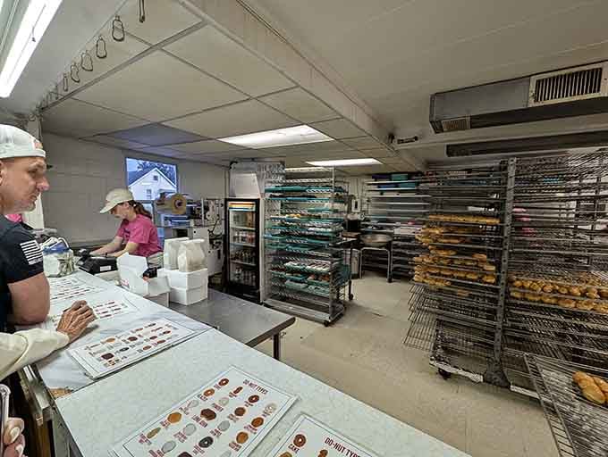 Behind the scenes where the magic happens, racks of fresh donuts cooling like edible treasure.