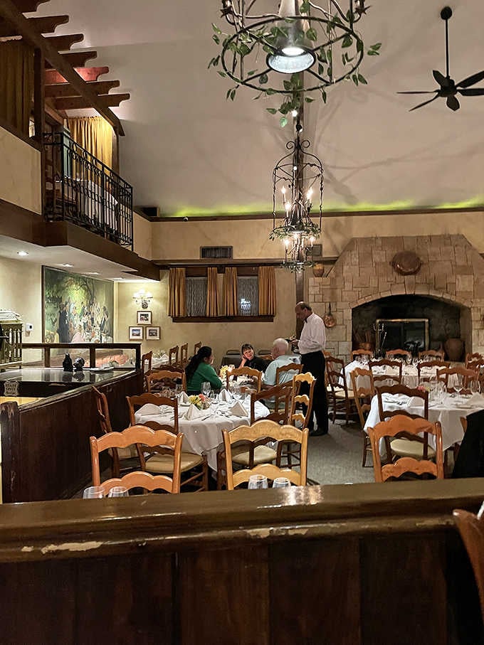 White tablecloths, a stone fireplace, and wrought iron chandeliers wrapped in greenery. France called and it wants its dining room back.