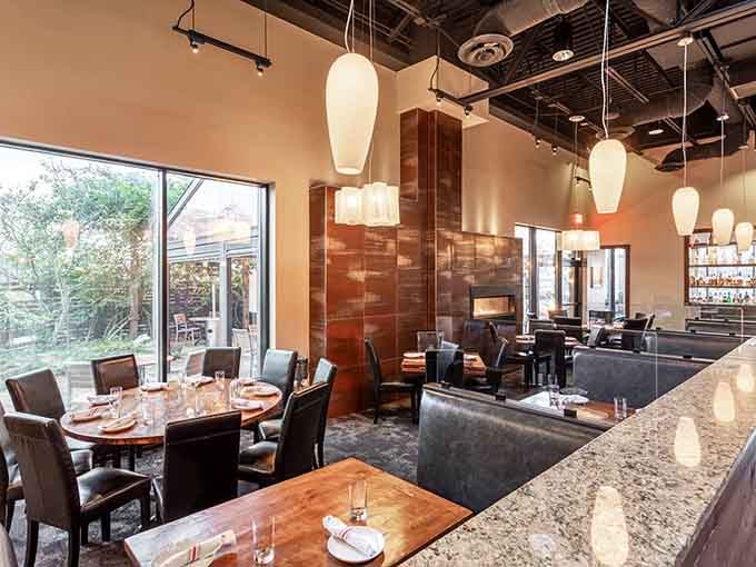 Warm pendant lights, a granite bar, and a glimpse of the garden patio through those windows. Yes, please.