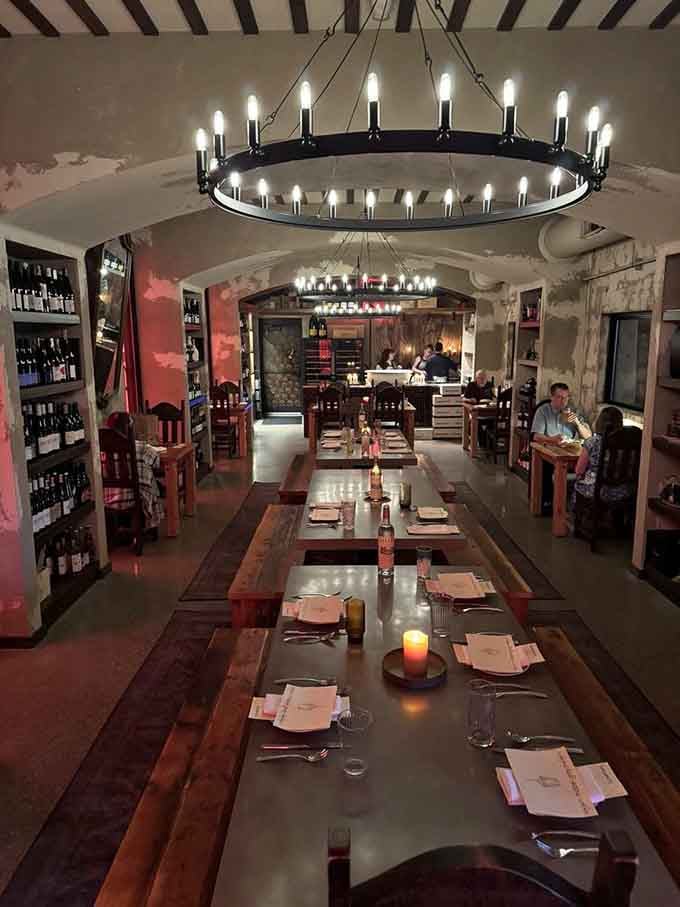 Those circular chandeliers and communal tables create an atmosphere that's somehow both medieval feast hall and modern dinner party.