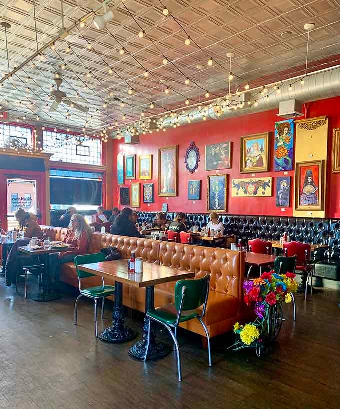 Tin ceilings, tufted booths, and colorful art create an atmosphere where every meal feels like a celebration.