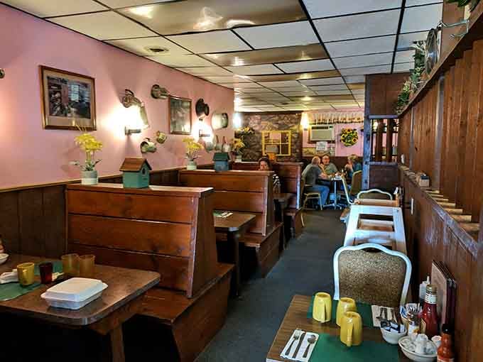 Warm pink walls, cozy wooden booths, and fresh flowers. This is what "come on in" actually looks like.
