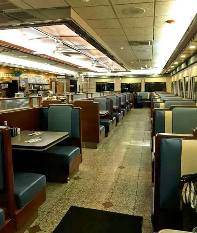 Rows of blue vinyl booths stretching into the distance, each one quietly promising a conversation worth having.