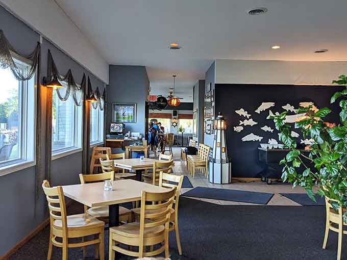Fishing nets on the windows, white fish silhouettes on the wall, and a lighthouse centerpiece that says "you're exactly where you should be."