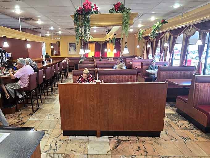 Burgundy booths, warm lighting, and hanging greenery overhead, this dining room feels like a hug you didn't know you needed.