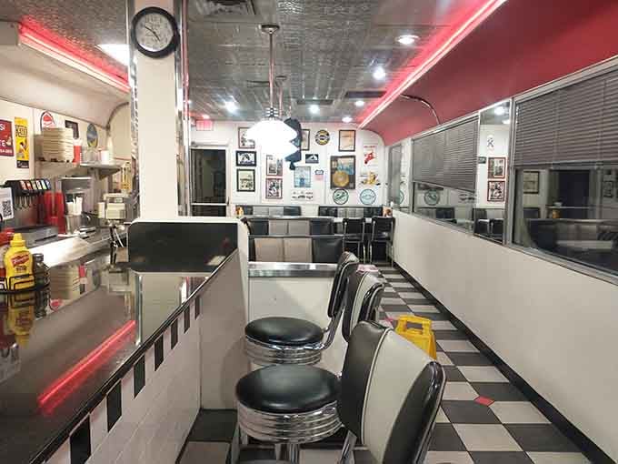 Black and white floors, chrome stools, red neon glow. This interior means serious diner business.