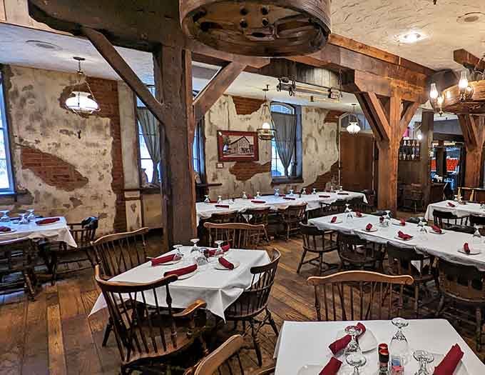 Heavy beams, white tablecloths, and a mill wheel overhead. History never looked this delicious or felt this welcoming.