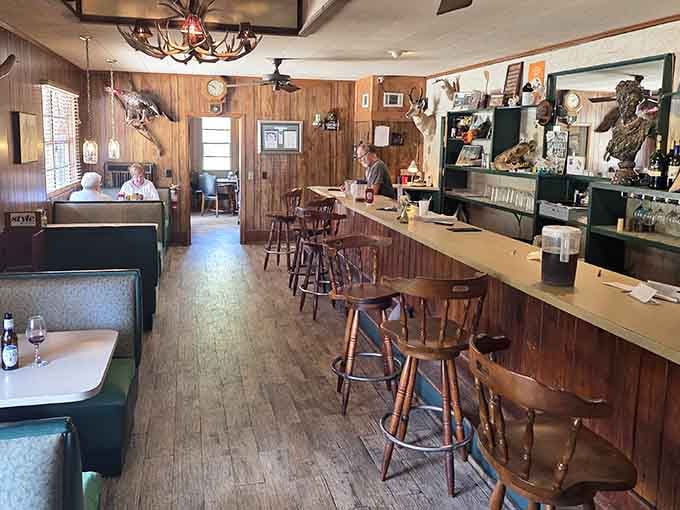 Wood paneling, antler chandeliers, and green vinyl booths. This is the kind of room that makes you want to stay a while.