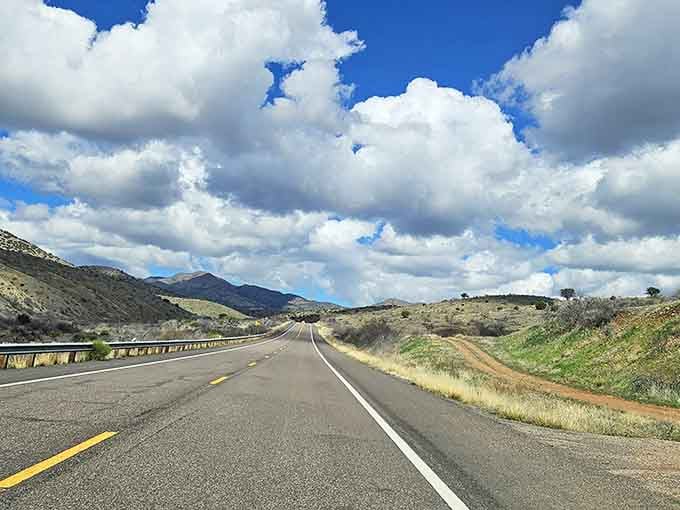 The open highway beckons with promises of adventure, dramatic clouds providing nature's own special effects overhead.