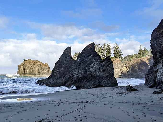 Dark volcanic rock meets silver sand in a scene that belongs on a postcard nobody's made yet.
