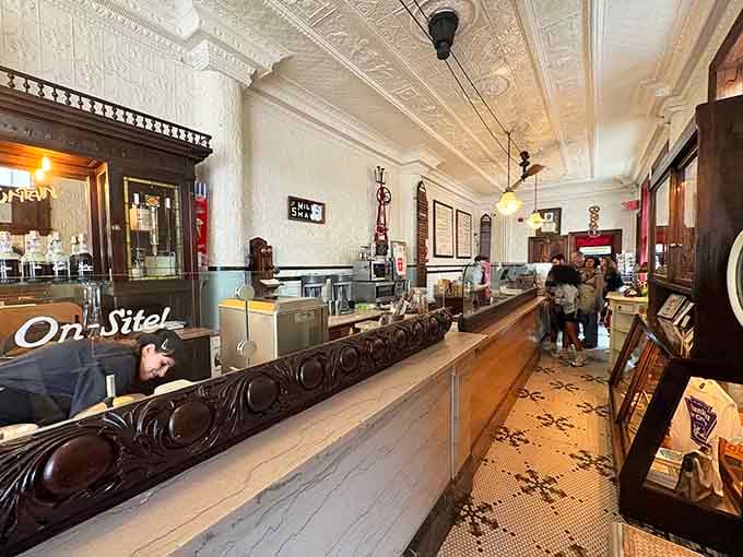 That long marble counter and carved dark wood base belong in a museum, yet somehow you get to eat here.