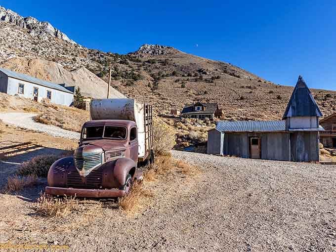A rusted truck parked forever beneath a cobalt sky, still waiting on a delivery that never came.
