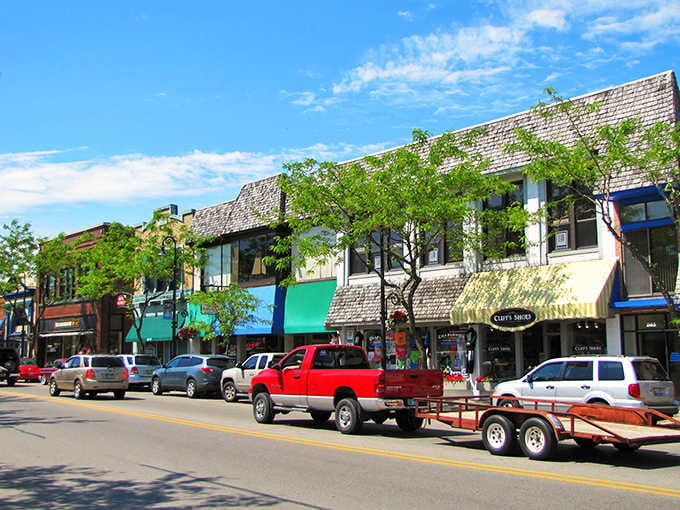 Charlevoix's cheerful downtown street buzzes with small-town energy, where colorful awnings and friendly storefronts make window shopping feel like a genuine adventure.
