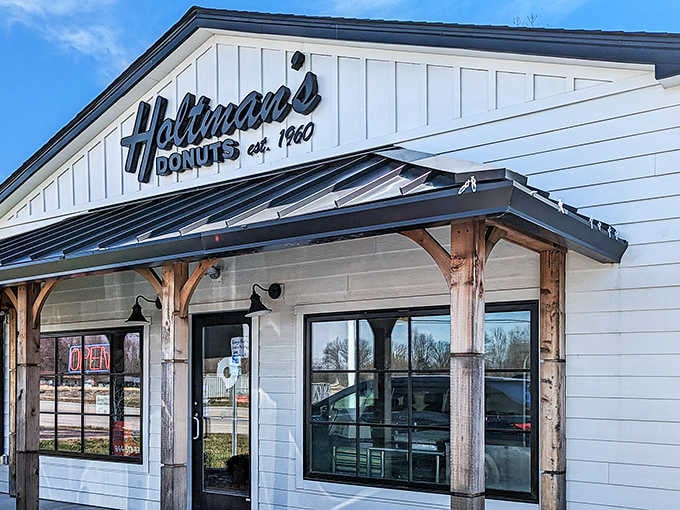 Rustic wooden posts, crisp white siding, and a metal roof that says this donut shop means serious, delicious business.