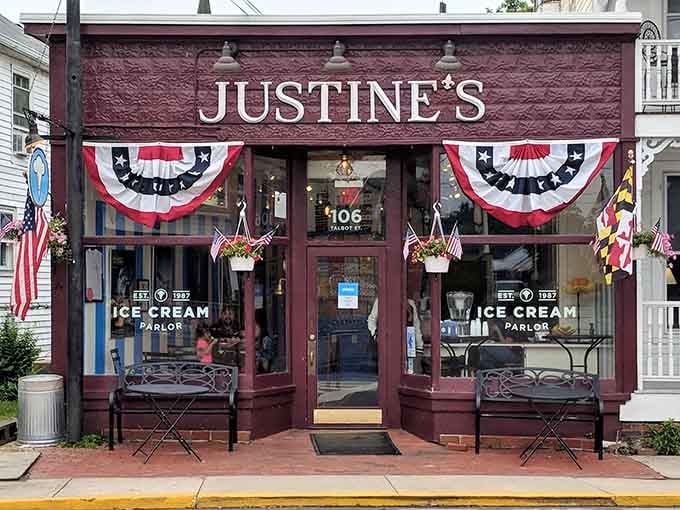 Patriotic bunting, Maryland flags, and iron benches — Justine's storefront in St. Michaels is dressed for a permanent celebration.