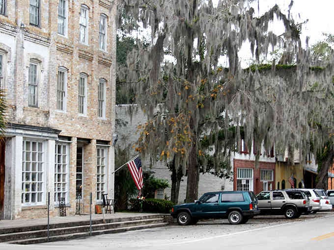 Spanish moss drapes from ancient oaks like nature's own beaded curtains, shading Micanopy's timeless brick streets below.