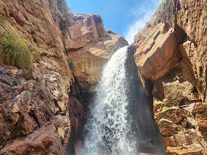 Red rock walls squeeze this waterfall into a roaring, mist-filled slot canyon that feels almost too dramatic to be real.