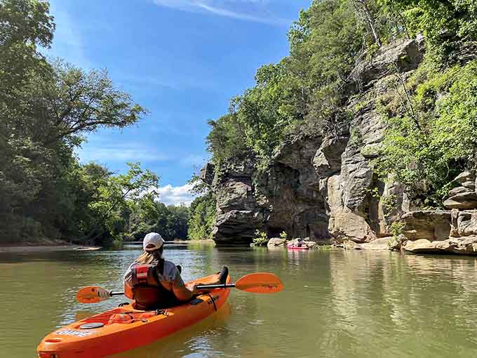 Towering bluffs create a natural cathedral as paddlers navigate through this stunning geological wonder carved by time.