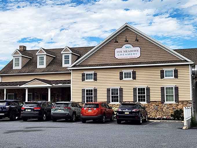 A full parking lot under big blue clouds tells you everything worth knowing about Fox Meadows Creamery.
