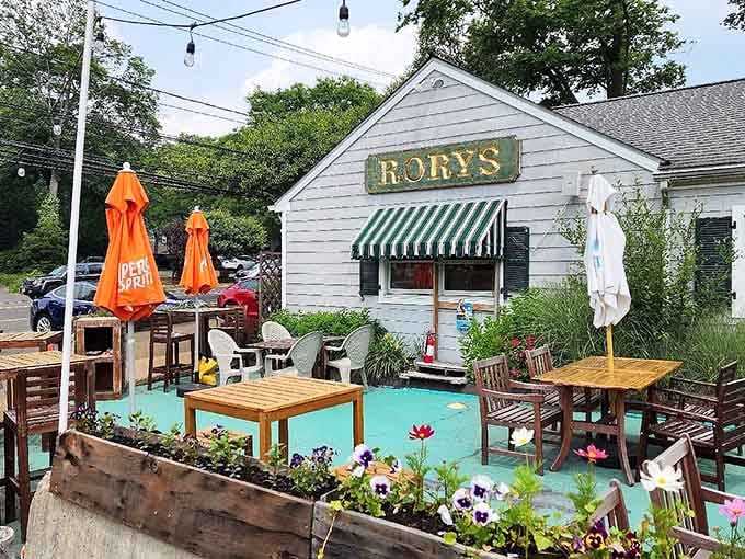 The striped awning and colorful outdoor setup create a backyard party vibe where seafood takes center stage daily.