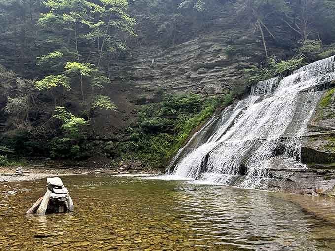 Water cascading down ancient rock shelves into a glassy pool feels like stumbling onto a secret jungle reward.