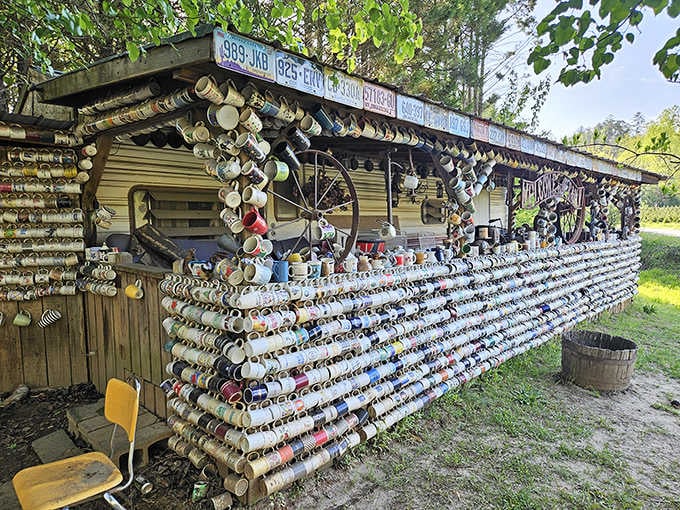License plates crown the roofline while mugs stack endlessly outward, turning a simple trailer into pure roadside poetry.