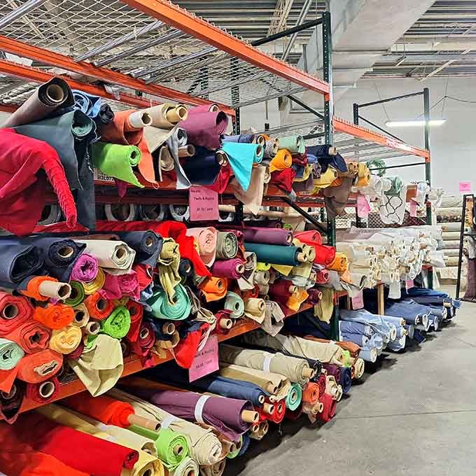 Industrial shelving packed floor to ceiling with solid fabric rolls, every shade your creative heart could possibly desire.