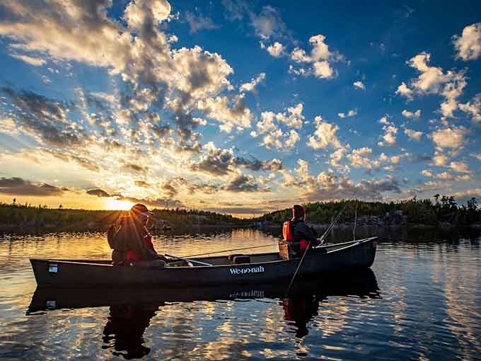 Two people, one canoe, and a sky so dramatic it makes every other sunset feel like it owes you an apology.